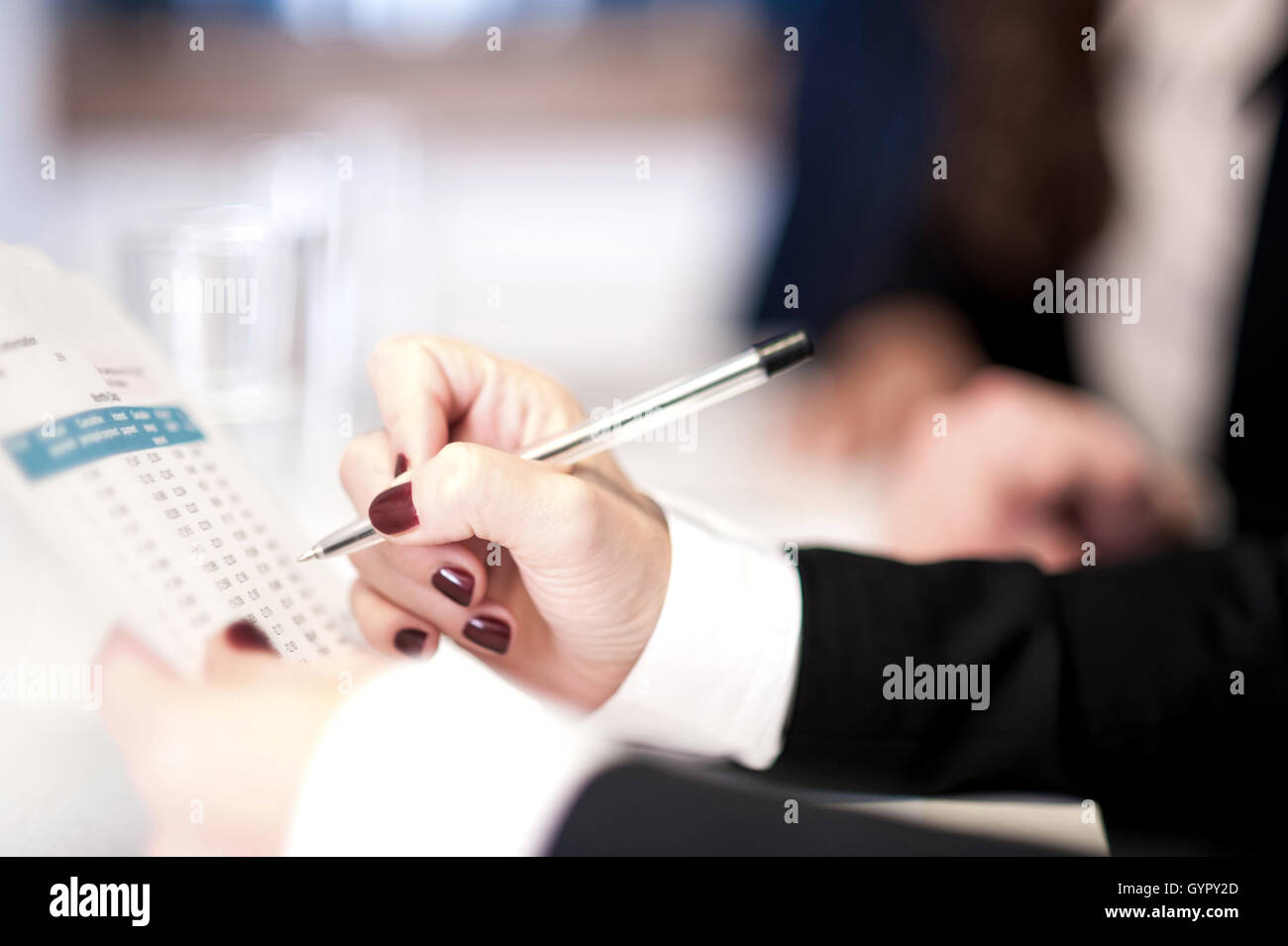 Woman cross-checking business reports Stock Photo - Alamy