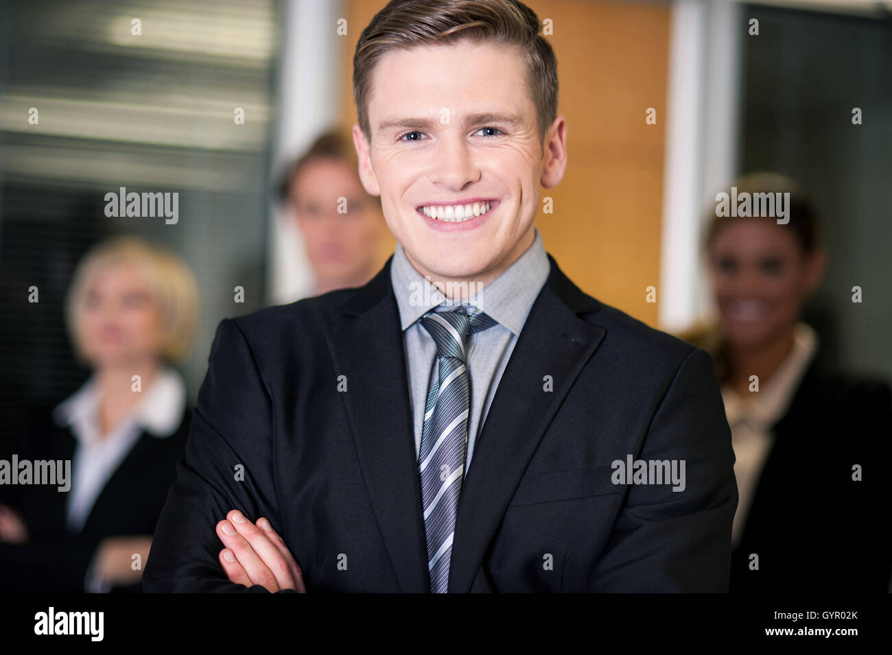 Friendly business people with male leader in front Stock Photo - Alamy