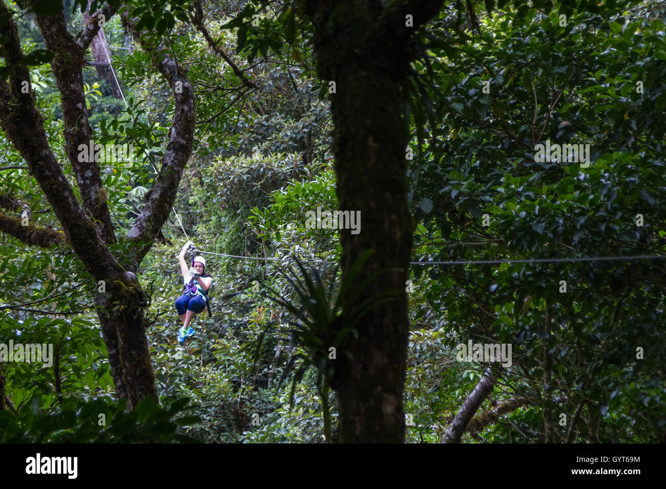 Young woman zip lining hi-res stock photography and images - Alamy
