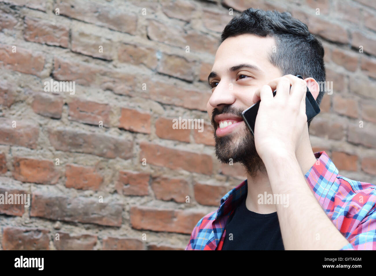 Handsome young latin man talking on the phone. Trendy and urban scene ...