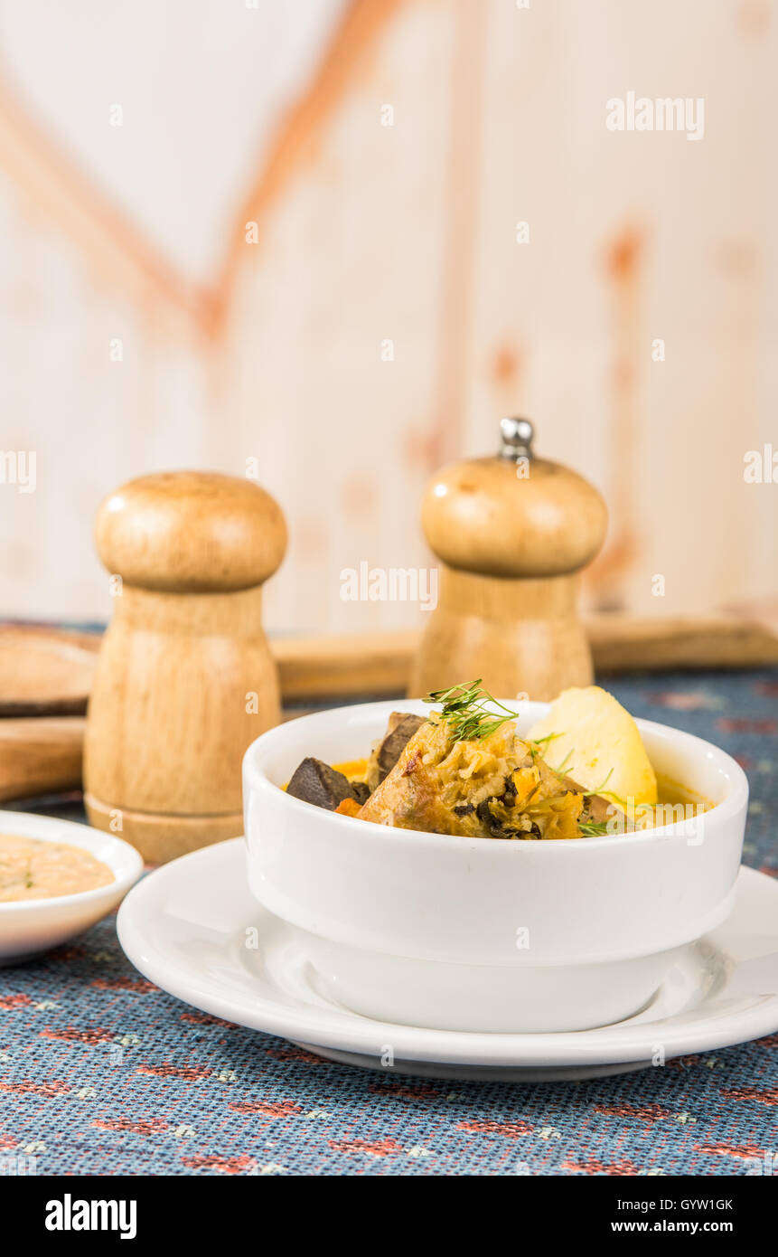 Classy serving of potato soup with meat and vegatables, served in white ...