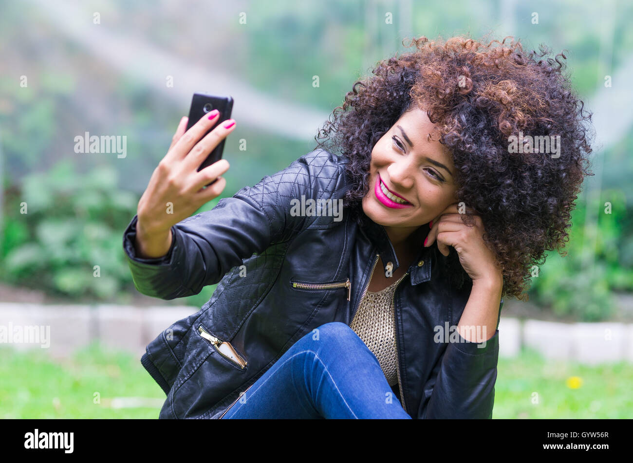 exotic beautiful young girl taking a selfie sitting in the garden Stock ...