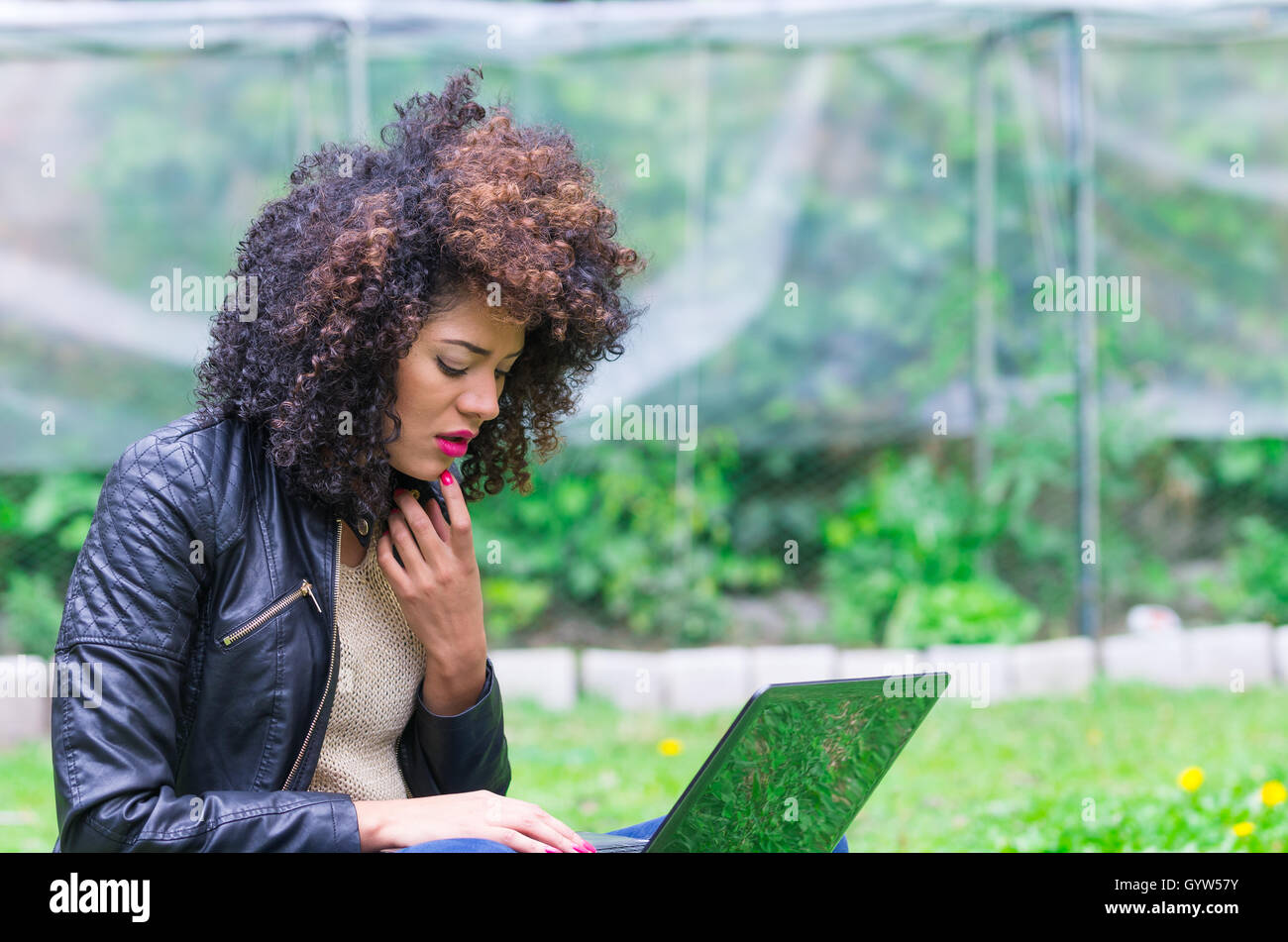 exotic beautiful young girl using laptop in the garden Stock Photo - Alamy