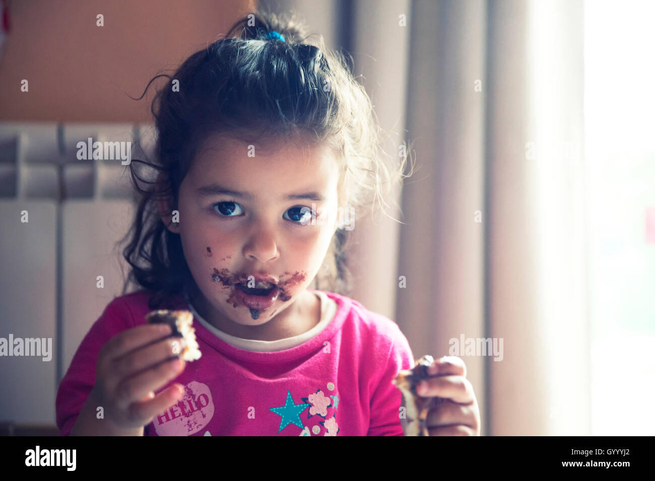 Girl with dirty mouth eating chocolate cookie Stock Photo - Alamy