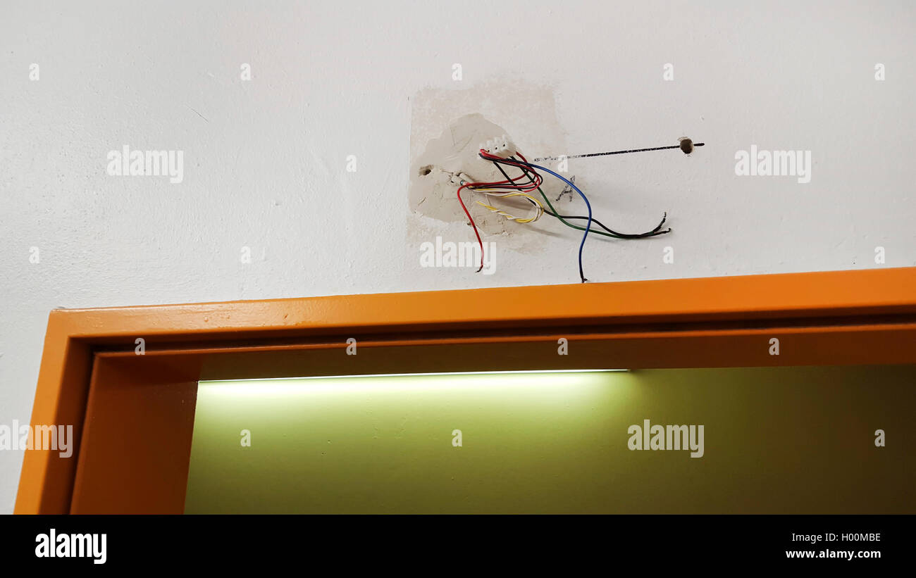 power cables of a destroyed and missed emergency exit sign above a door ...