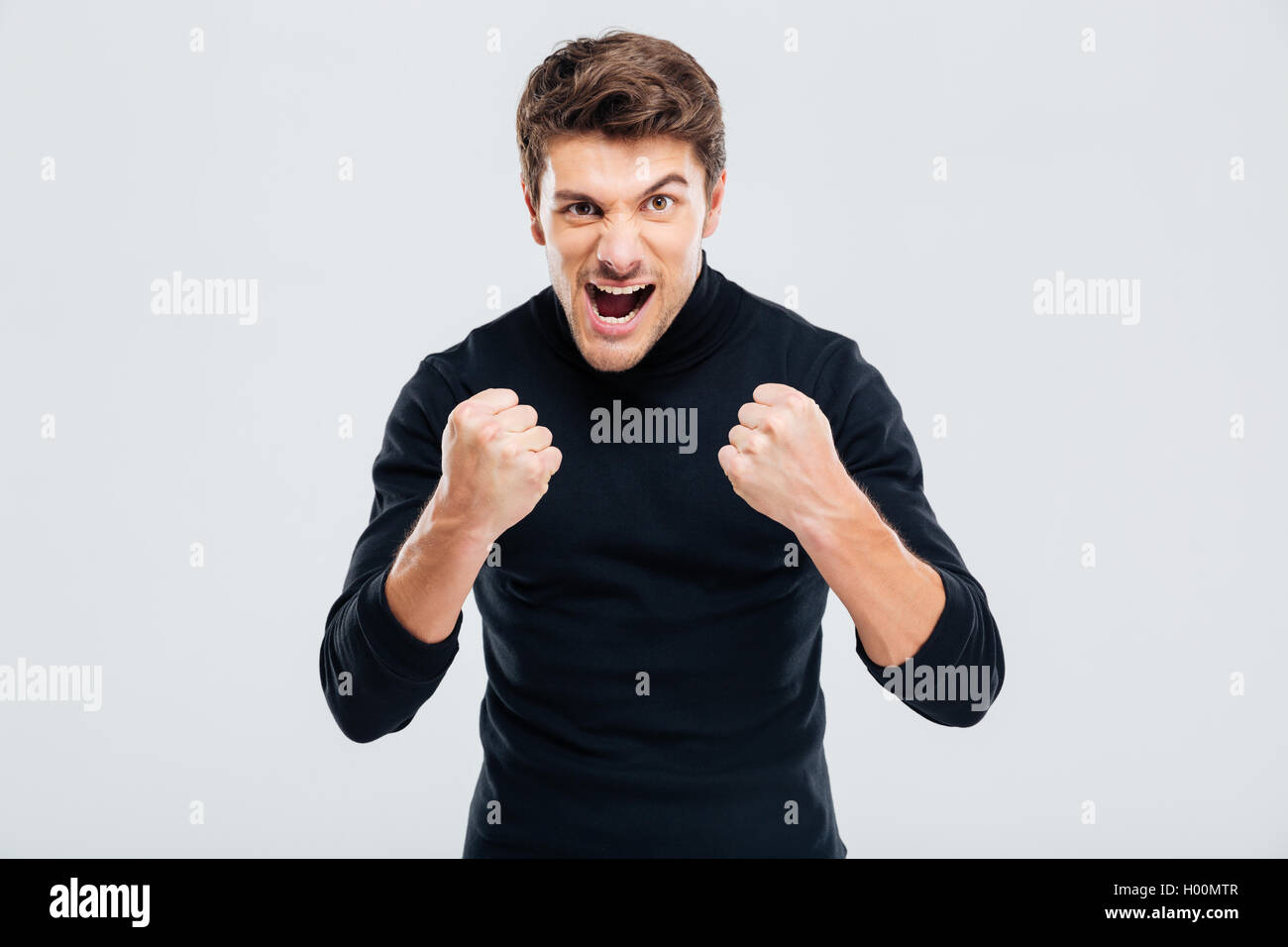 Mad crazy young man threatening with fists and shouting Stock Photo - Alamy