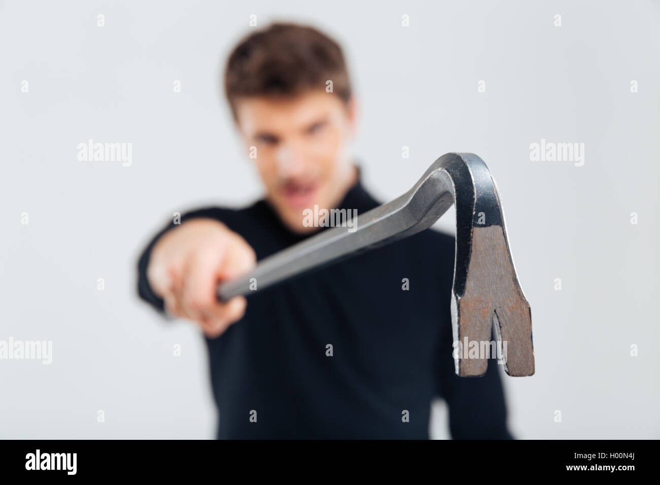 Closeup of angry burglar standing and holding crowbar Stock Photo - Alamy