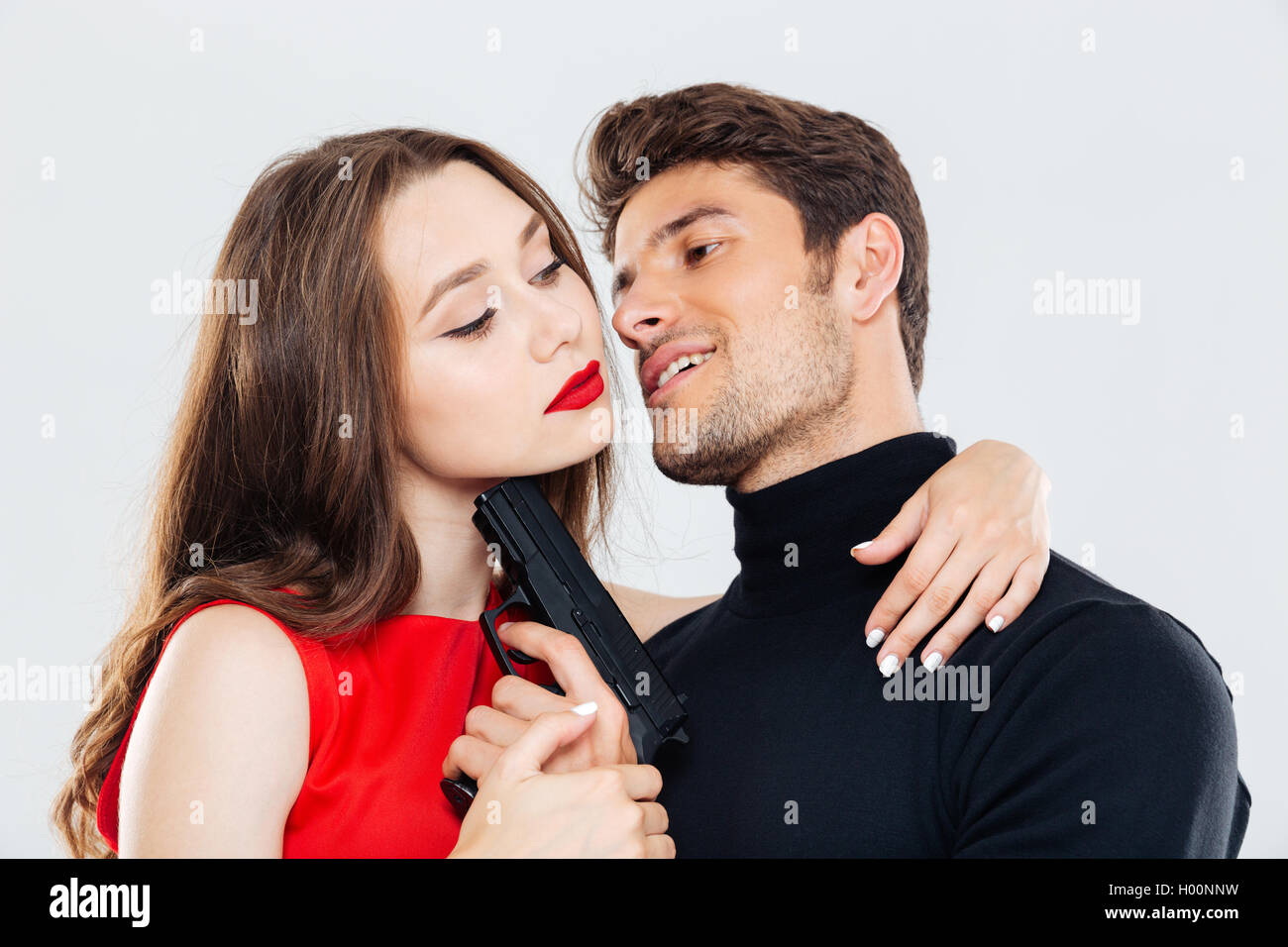 Sensual young couple hugging and posing with gun Stock Photo - Alamy