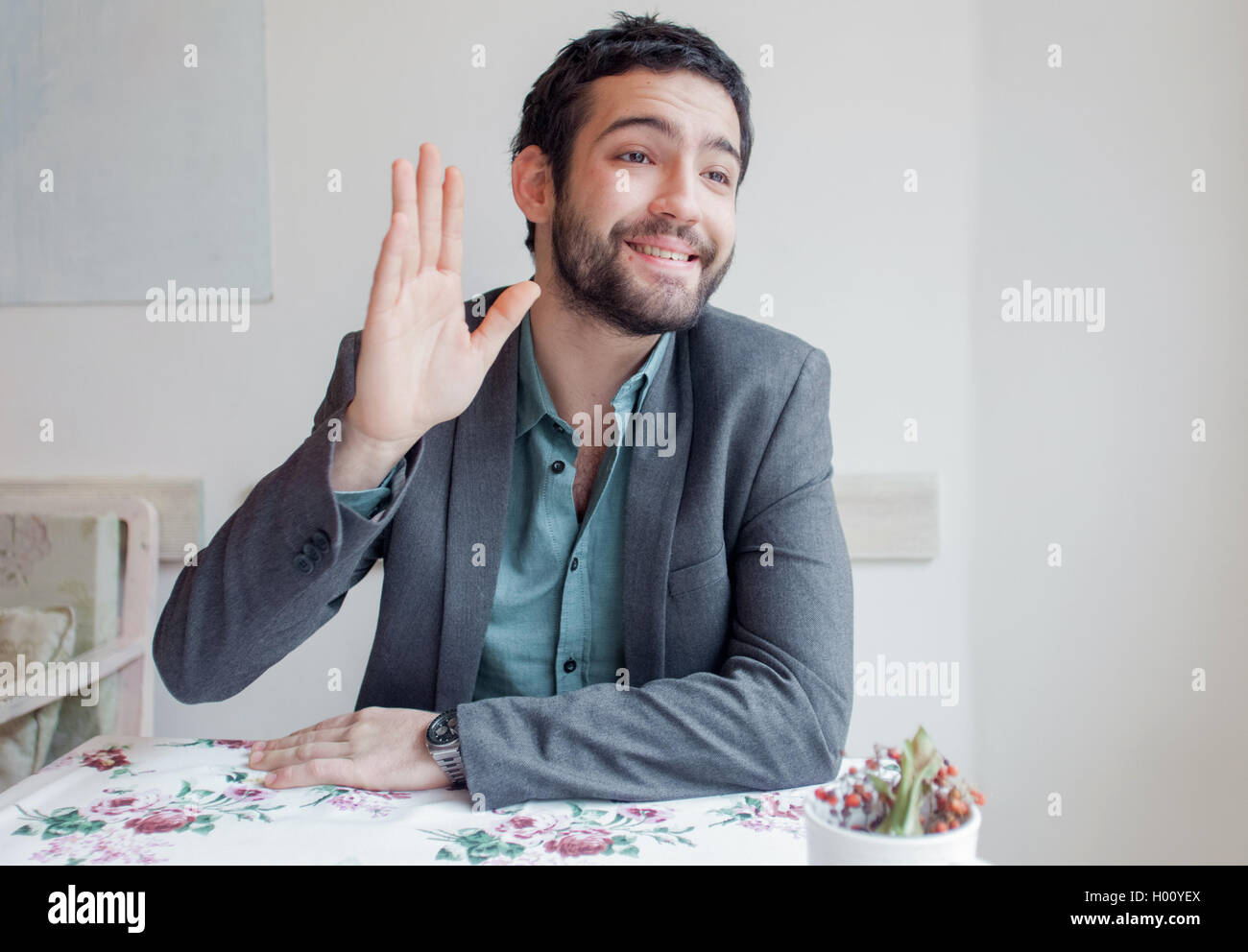 Young man wearing jacket sitting in restaurant and calling waiter Stock ...
