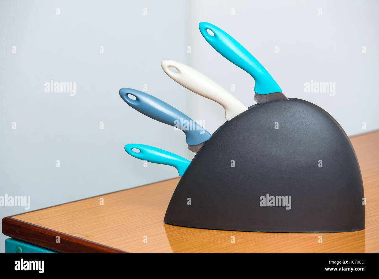 Multicoloured knife rack on kitchen table Stock Photo - Alamy