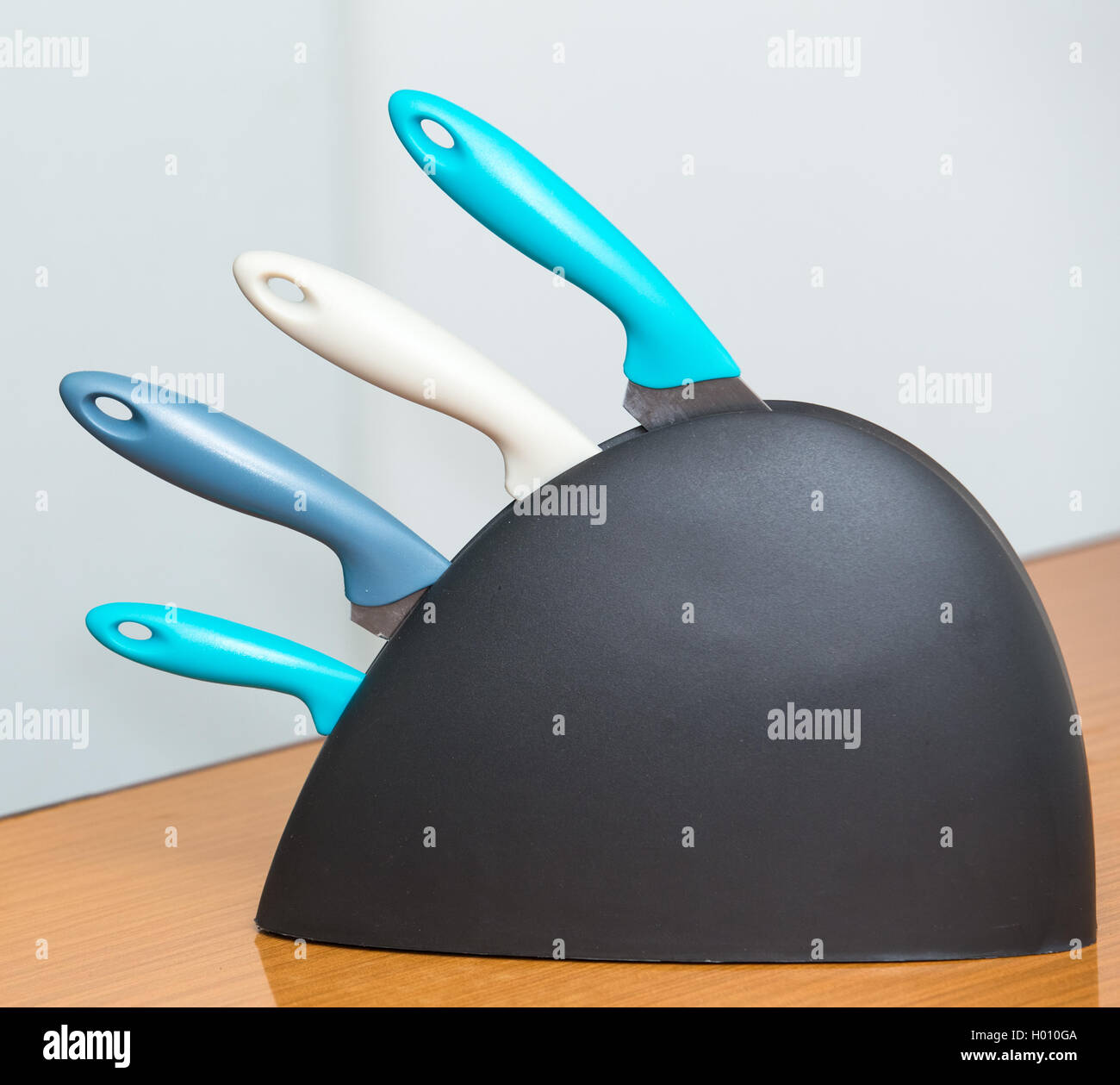 Multicoloured knife rack on kitchen table Stock Photo - Alamy