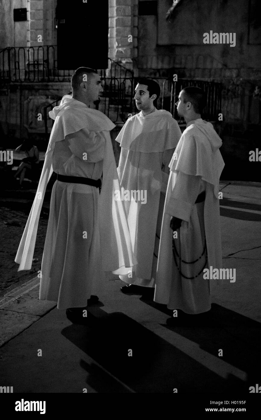 Three priest standing outside church at night Stock Photo - Alamy
