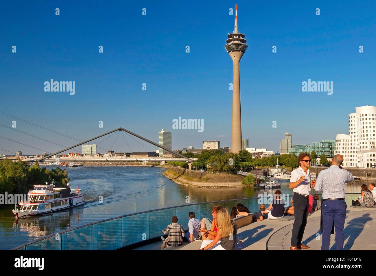 people on a restaurant terrace with view onto the Rhine tower, Germany ...