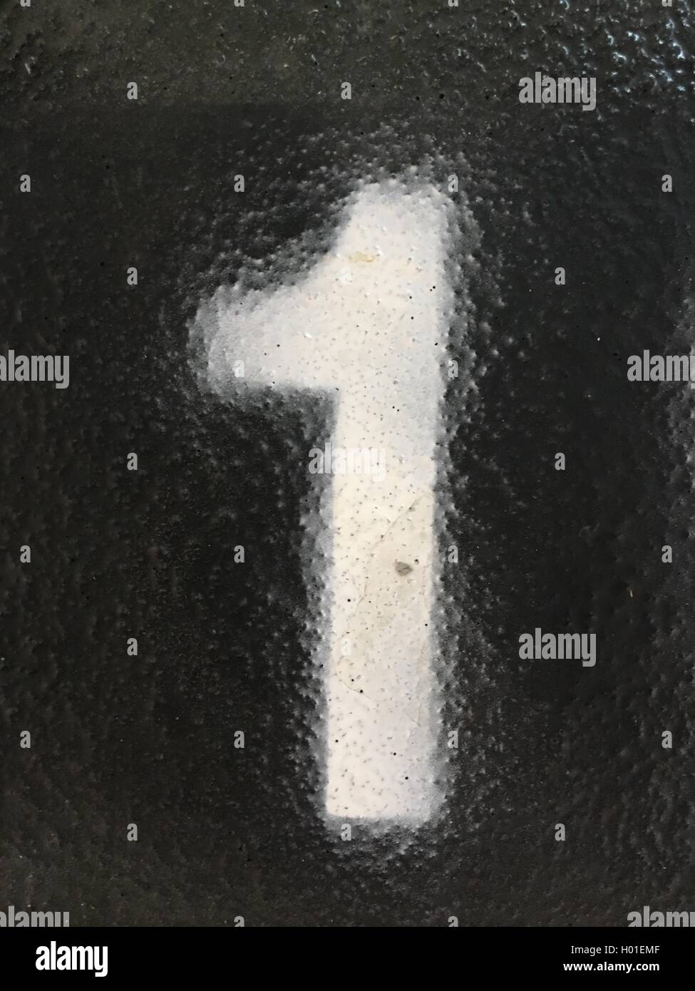 White Number 1 painted in stencil style on a the ground or wall Stock ...