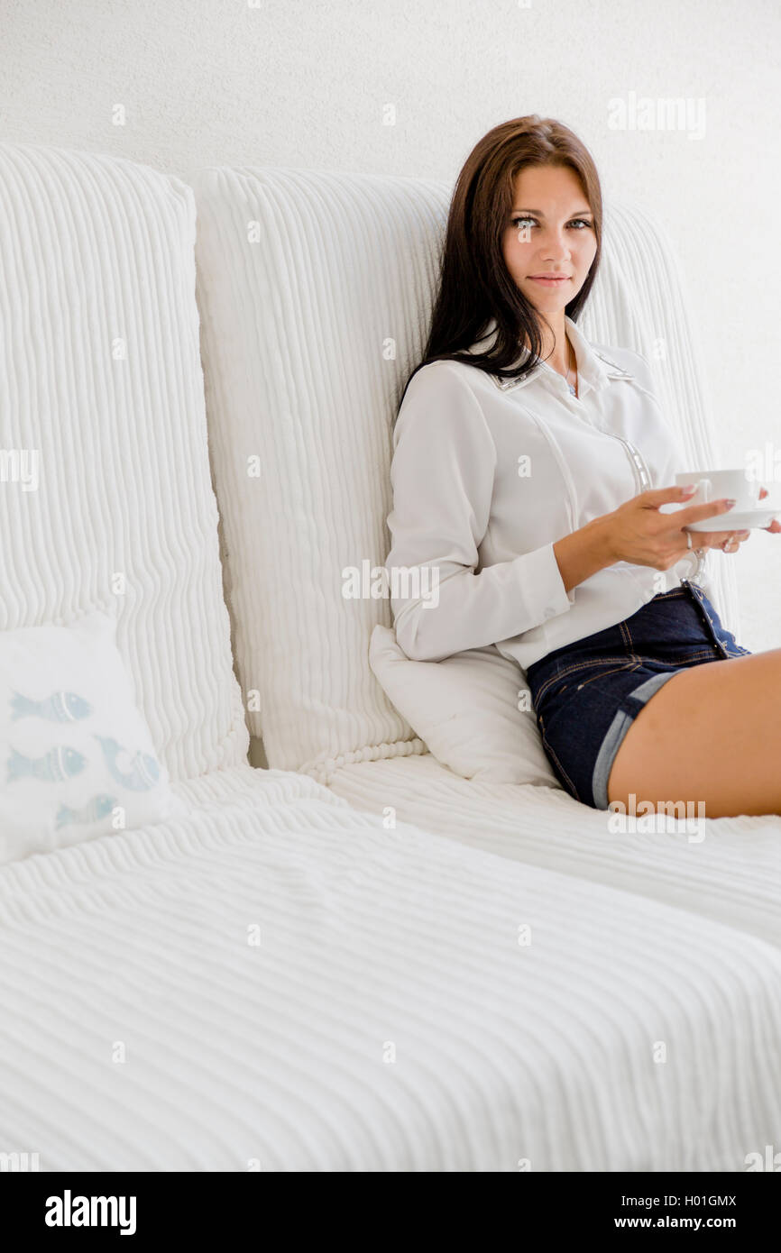 Beautiful young happy woman sipping tea Stock Photo - Alamy