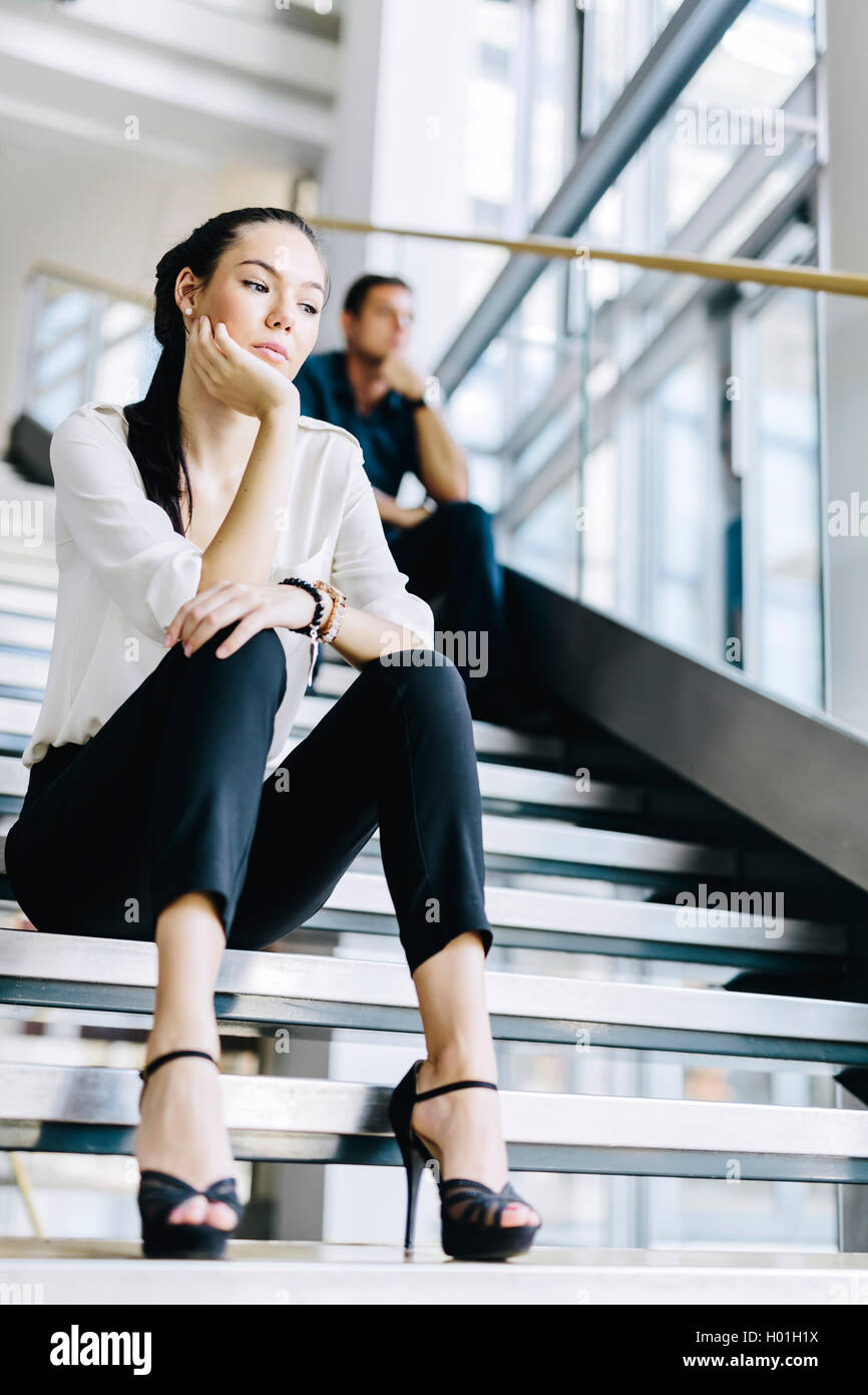 Business people sitting on stairs and thinking. Modern enterior Stock ...