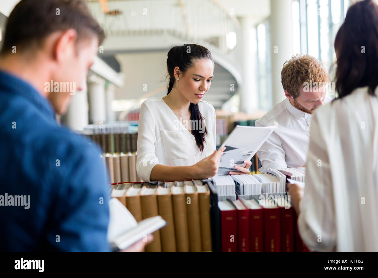 Group of students studying in library and reading books Stock Photo - Alamy