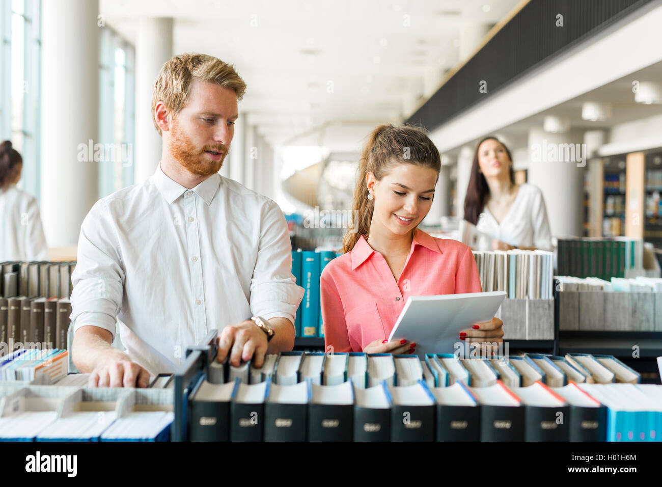 Two smart students reading and studying in library whole searching ...
