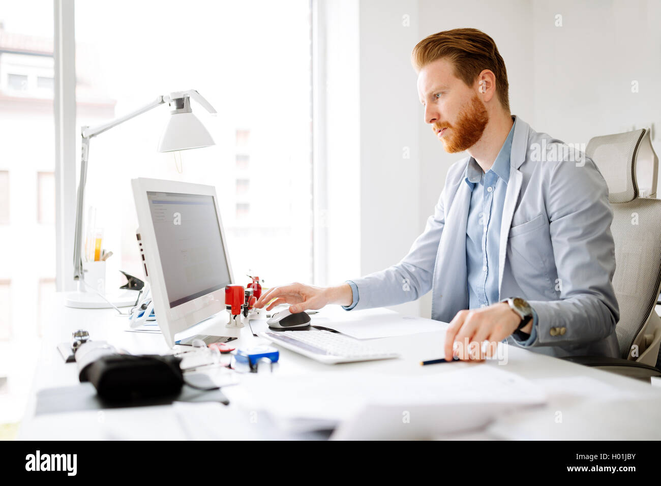 Business person working on computer at his office desk Stock Photo - Alamy