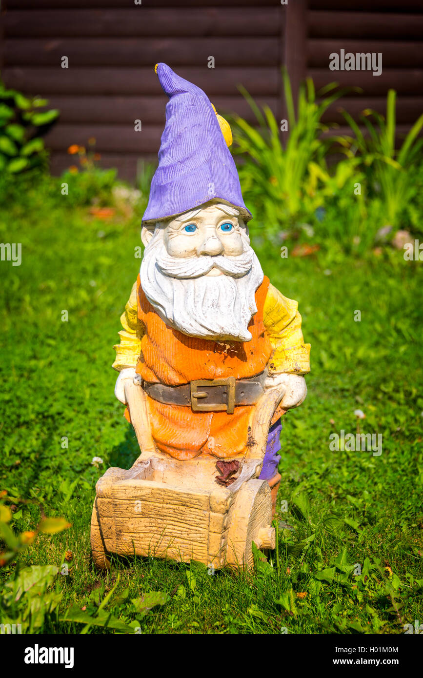 Garden dwarf with a wheelbarrow in a home garden Stock Photo - Alamy