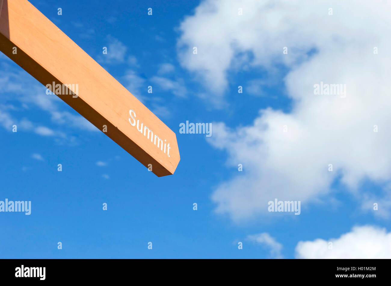 Sign against blue sky pointing to the summit Stock Photo - Alamy