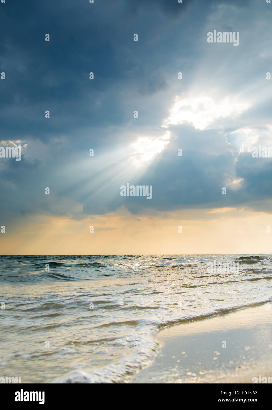 Sun rays breaking through the clouds at sunset Stock Photo - Alamy