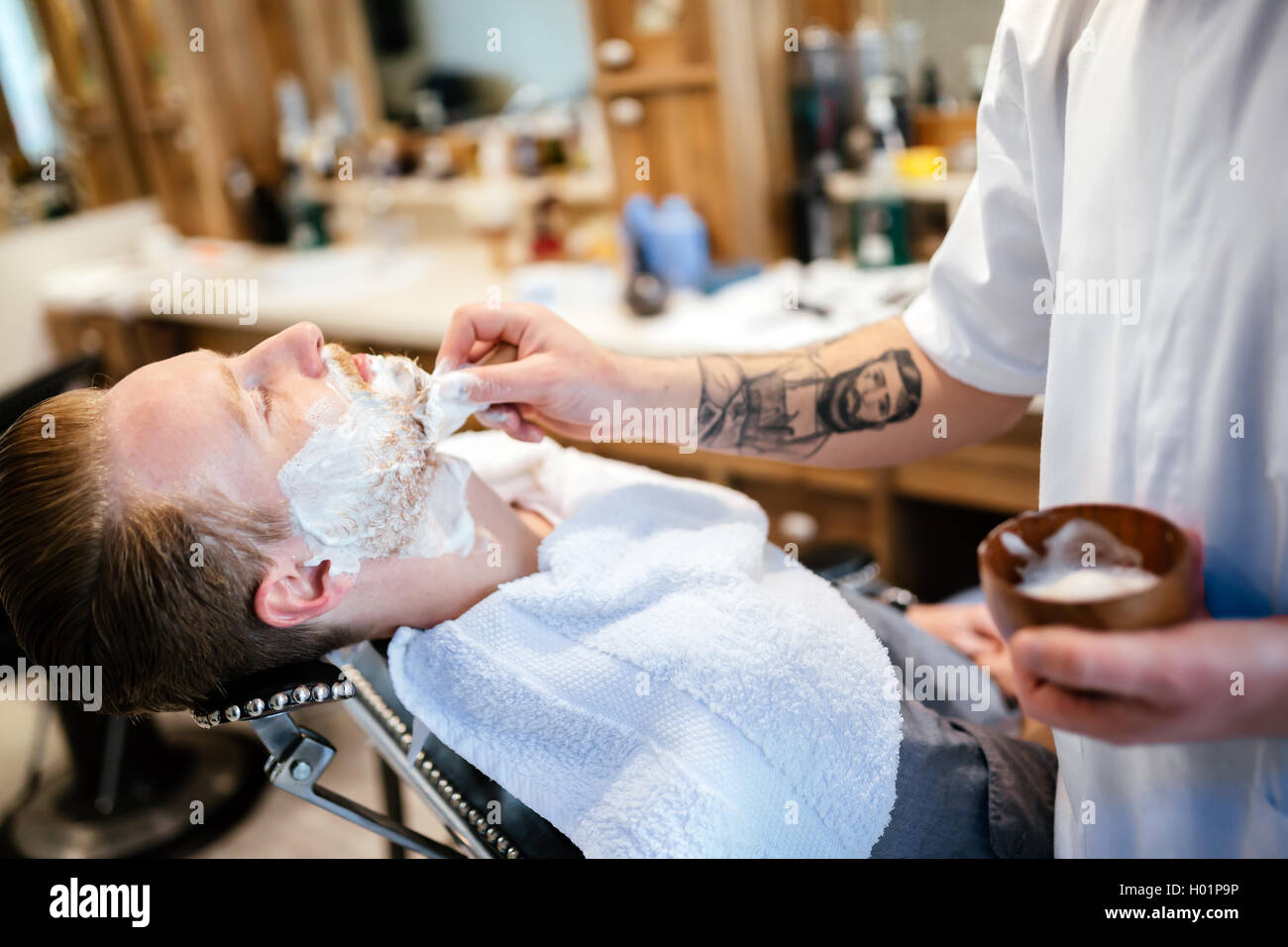 Male receiving hair beard treatment in barber shop Stock Photo - Alamy