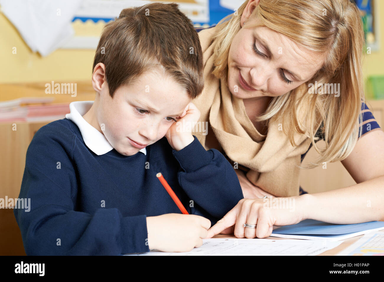 Teacher With Male Elementary School Pupil With Problem Stock Photo - Alamy