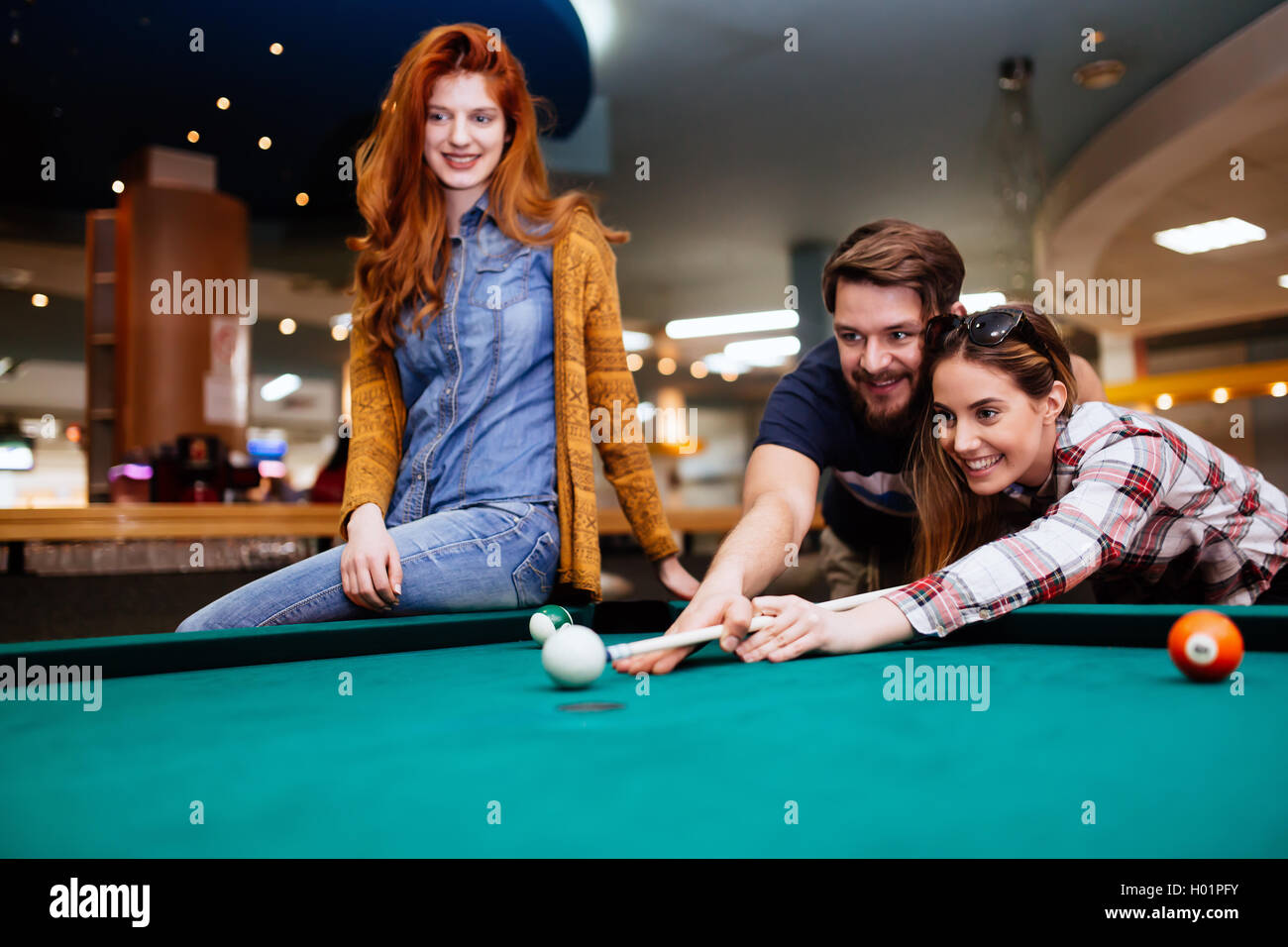 Happy friends enjoying playing pool together Stock Photo - Alamy