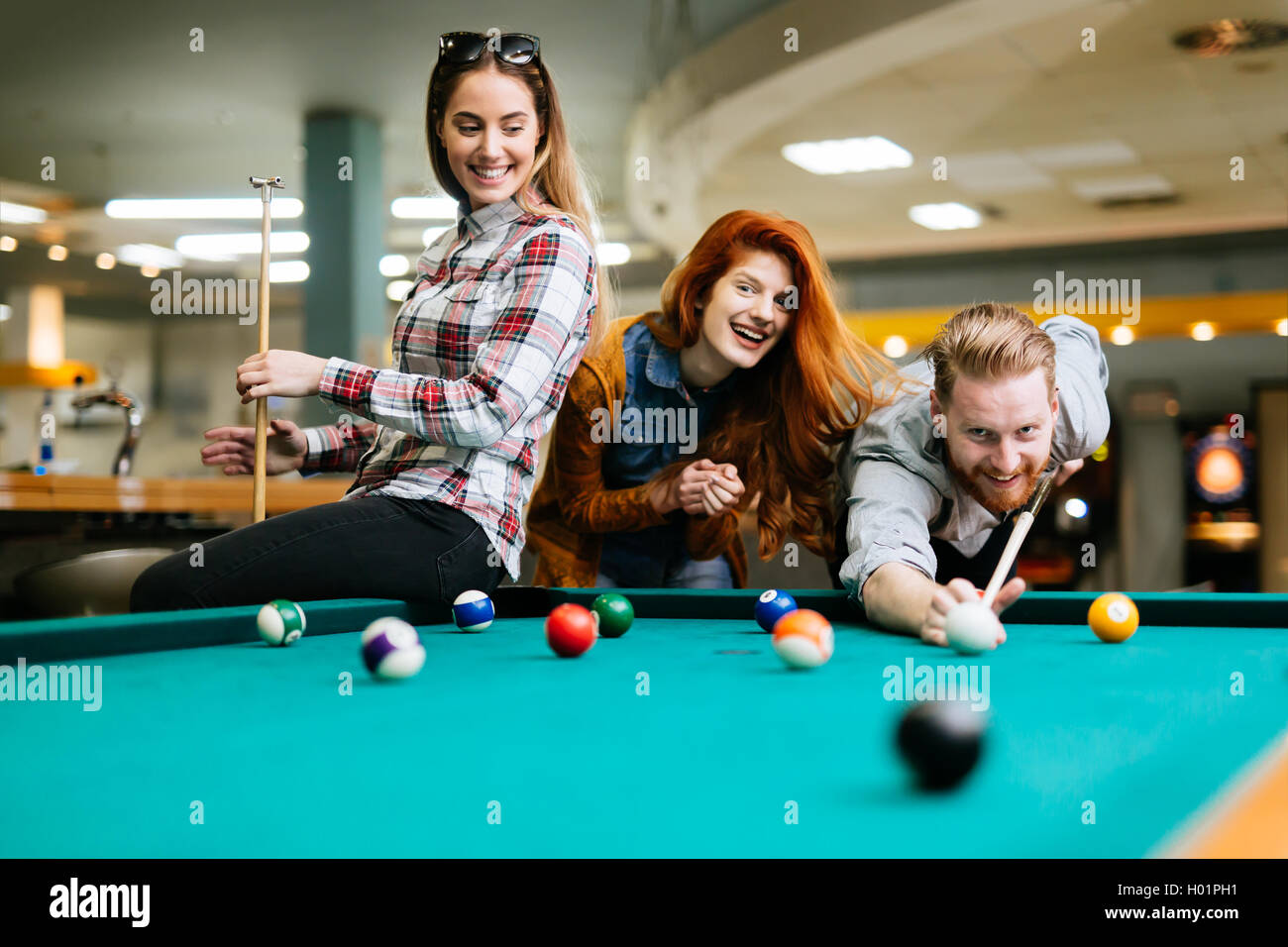 Happy friends enjoying playing pool together Stock Photo - Alamy