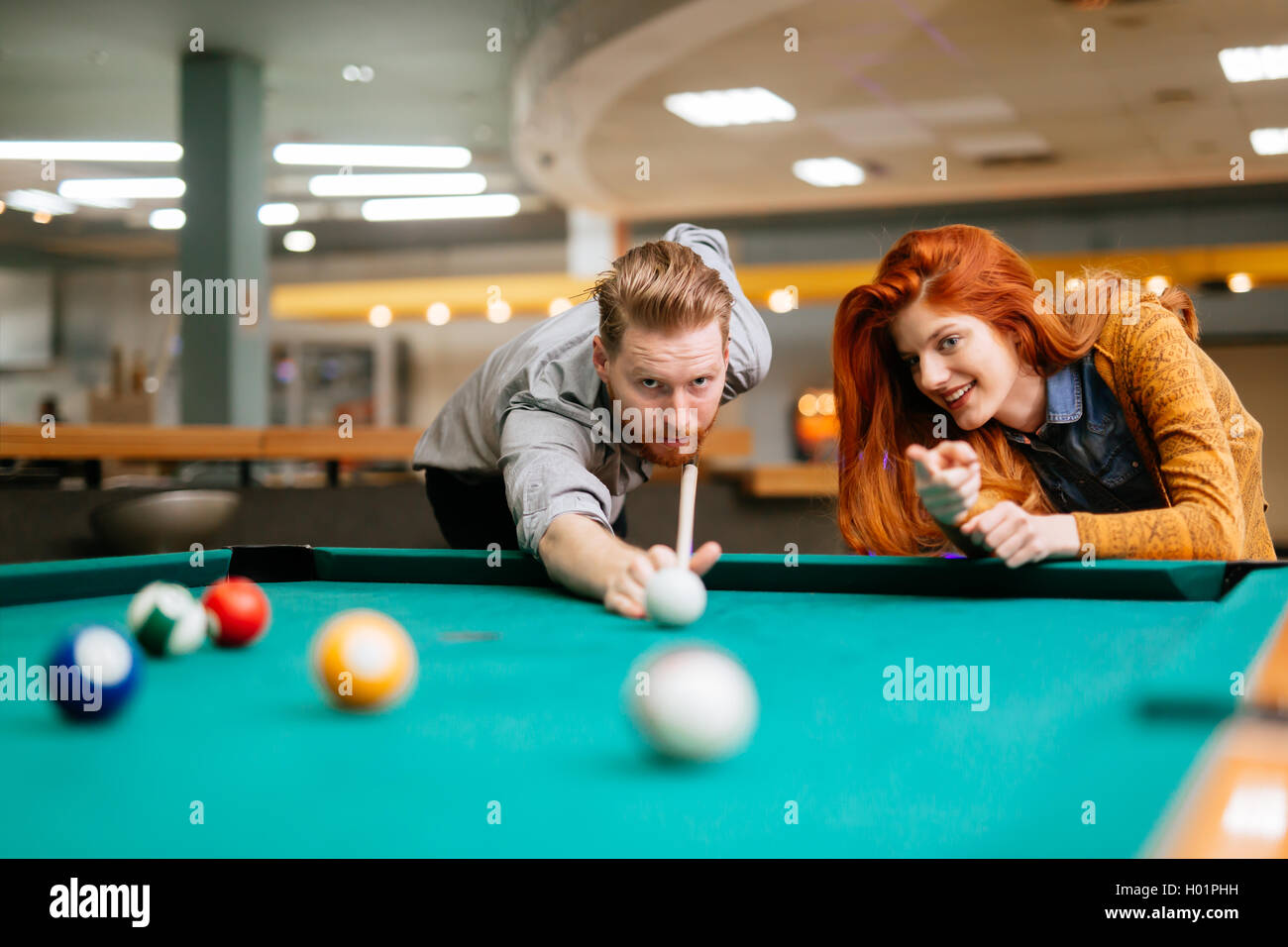 Beautiful happy couple playing billiards Stock Photo - Alamy