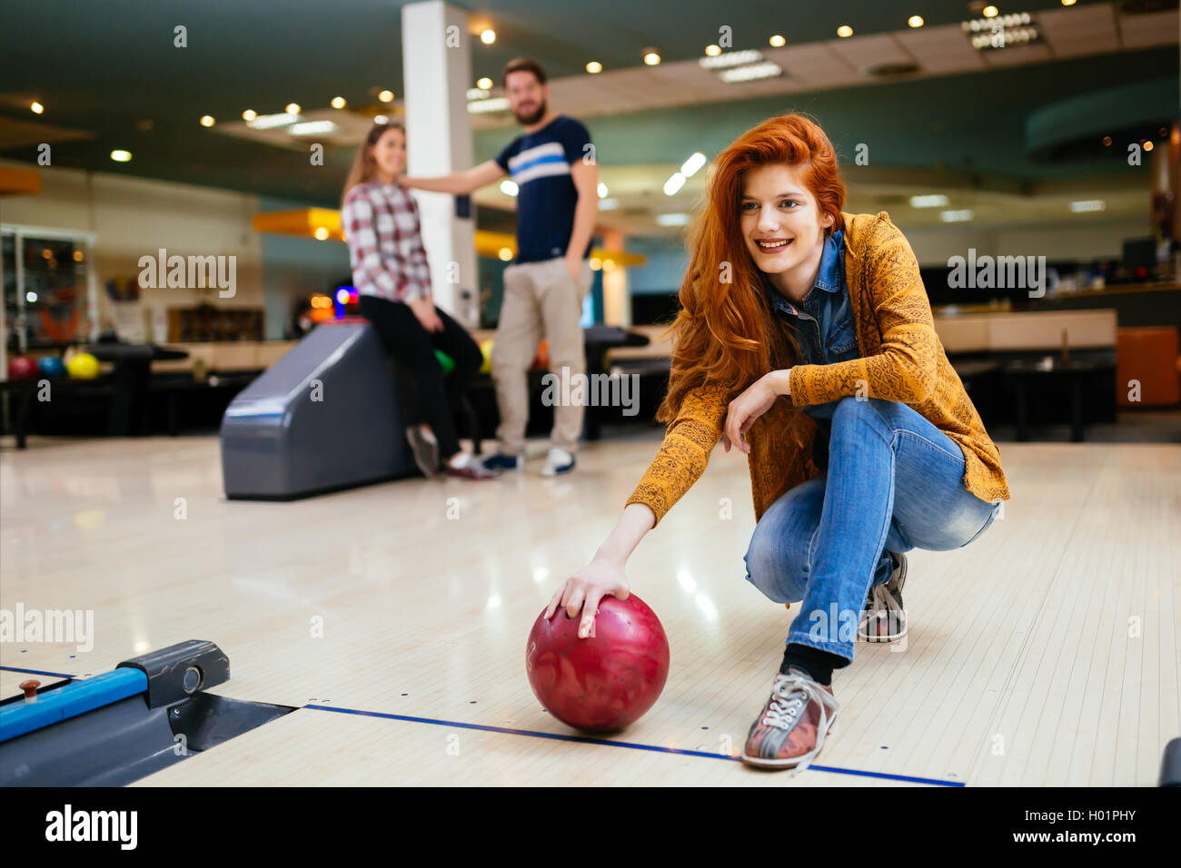 Friends enjoying competitive bowling Stock Photo - Alamy