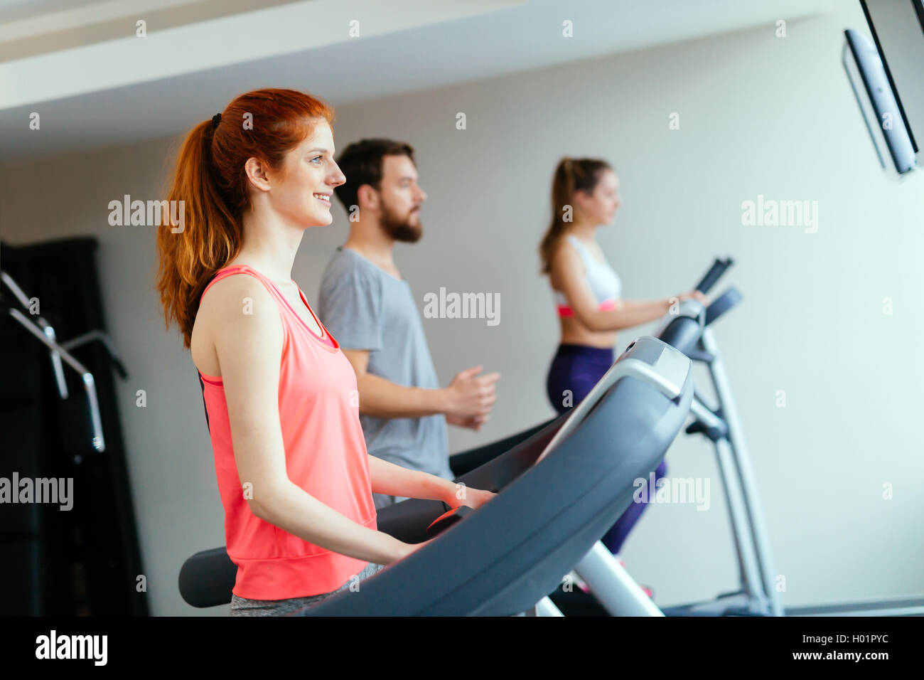 People traning in gym on various machines as part of cardio workout ...