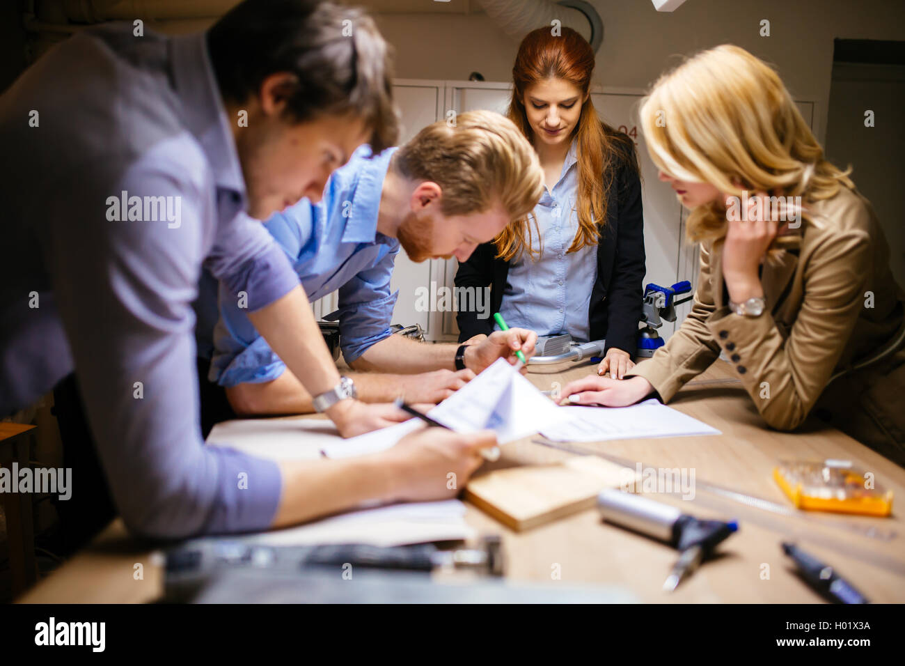 Classmates working on a project together and cooperating Stock Photo ...