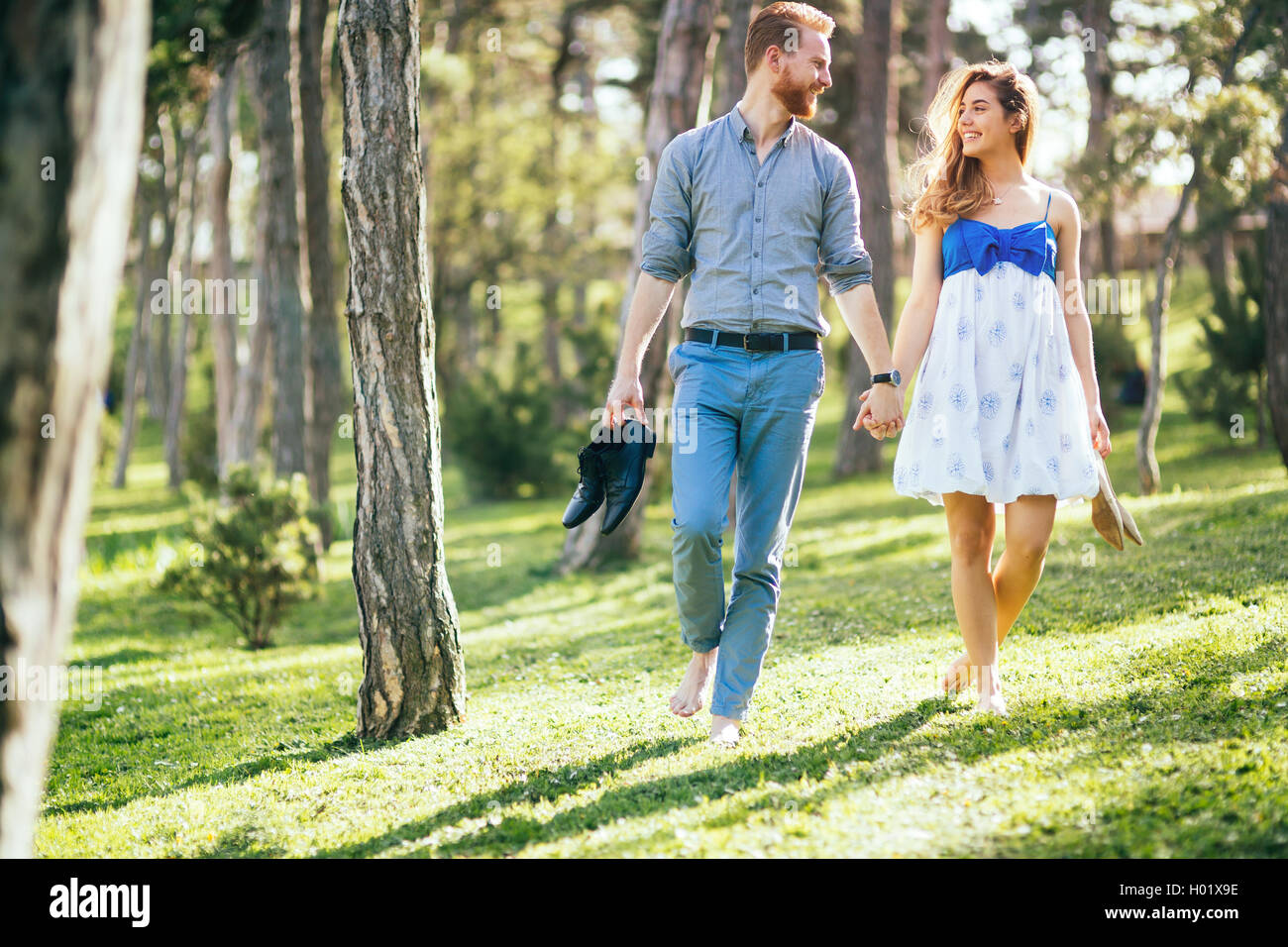 Couple enjoying romantic walk in nature barefoot Stock Photo - Alamy