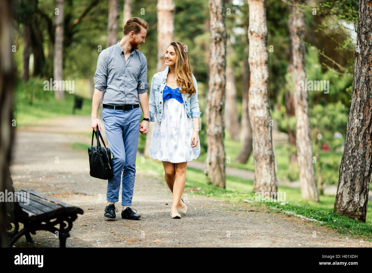 Beautiful couple taking a walk in city park Stock Photo - Alamy