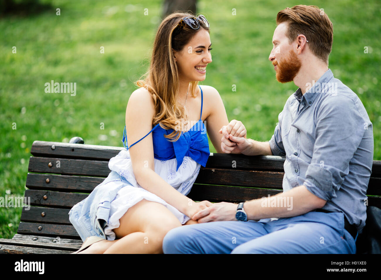 Romantic couple in love sitting on park bench Stock Photo - Alamy