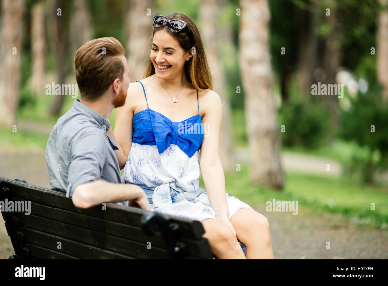 Romantic couple in love sitting on park bench Stock Photo - Alamy