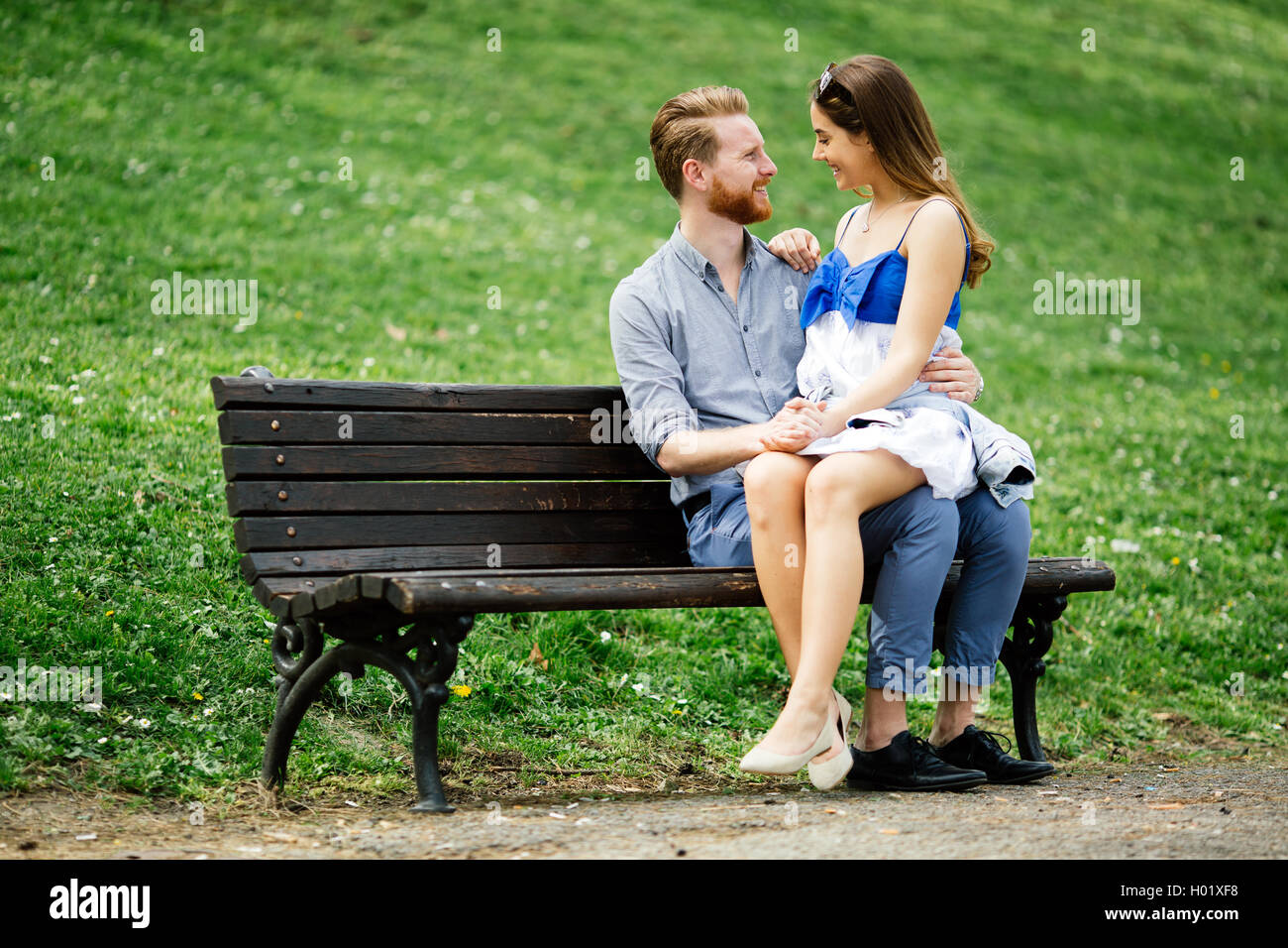 Romantic couple in love sitting on park bench Stock Photo - Alamy