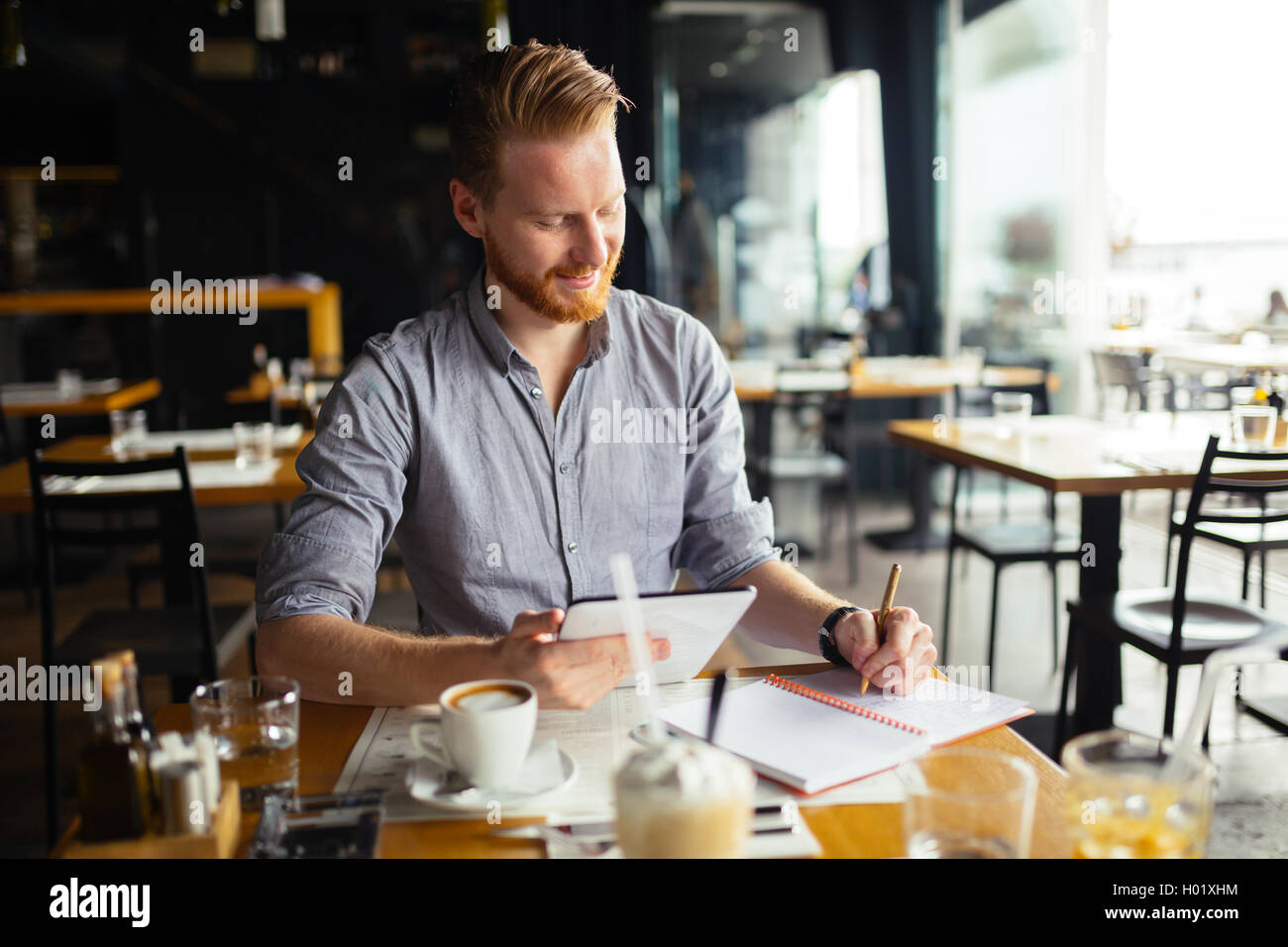 Businessman taking notes in cafe and writing down ideas Stock Photo - Alamy