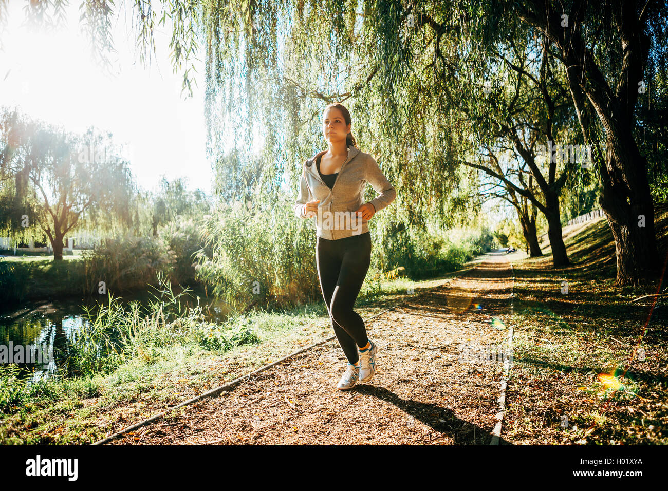 Beautiful woman jogging in a park Stock Photo - Alamy