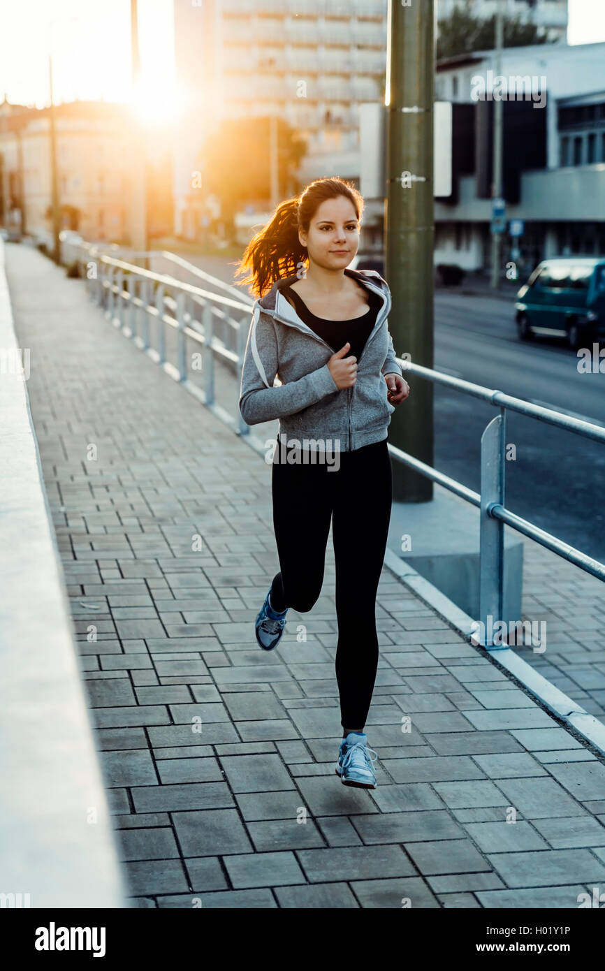 Sporty woman jogging in city to keep her body and soul in shape Stock ...