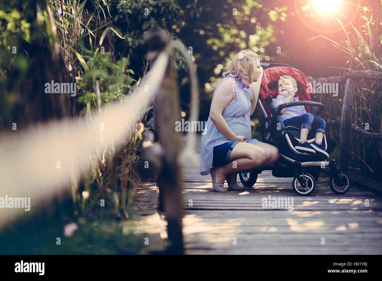Pregnant woman with her child in pram walking in nature Stock Photo - Alamy