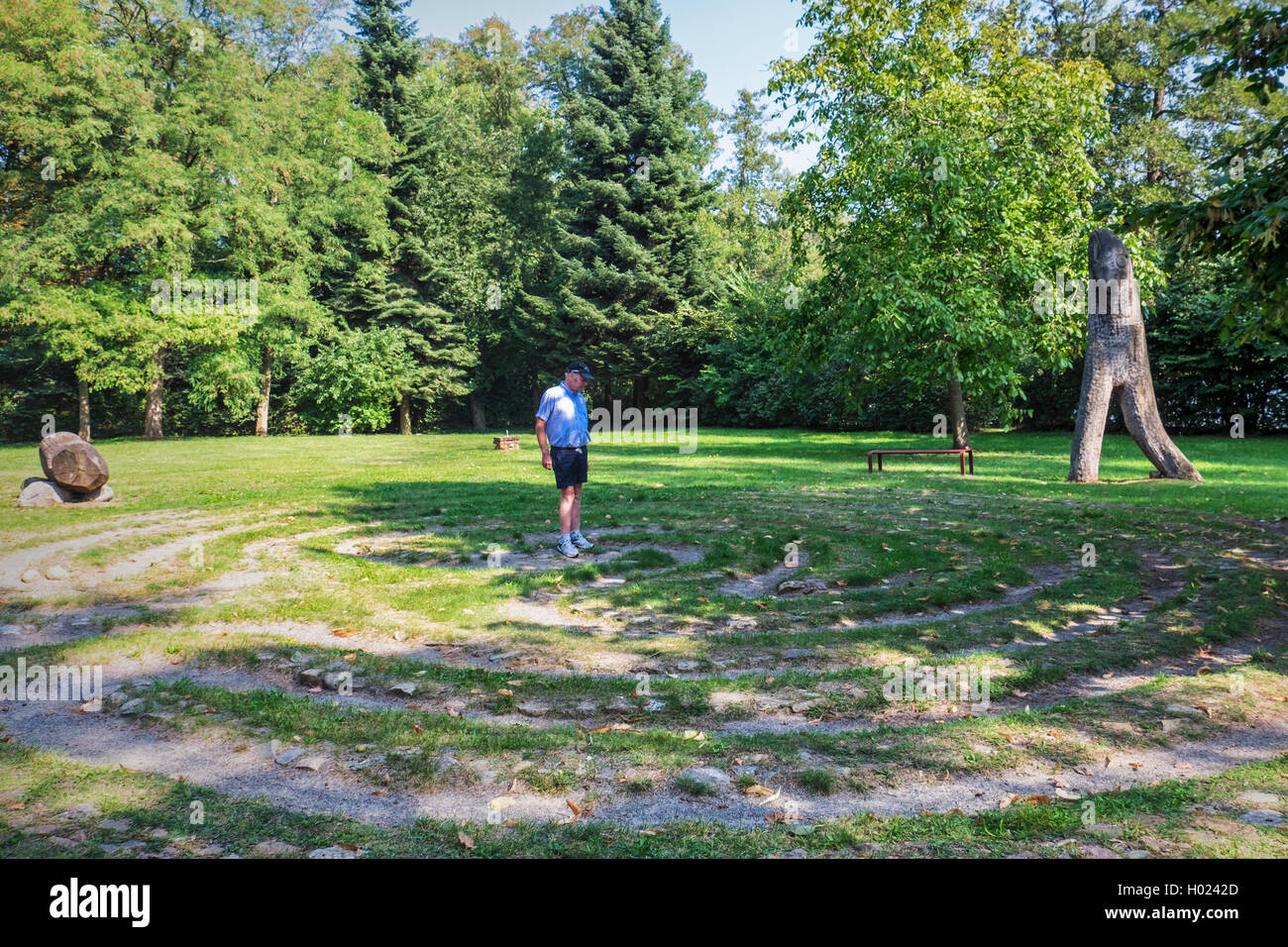 Labyrinth, wooden sculpture and elderly tourist at Himmelpfort (Heaven ...