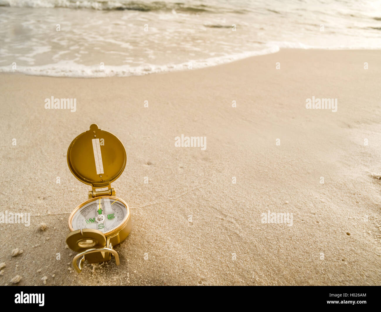 Compass indicating North direction lying on the sandy beach Stock Photo ...