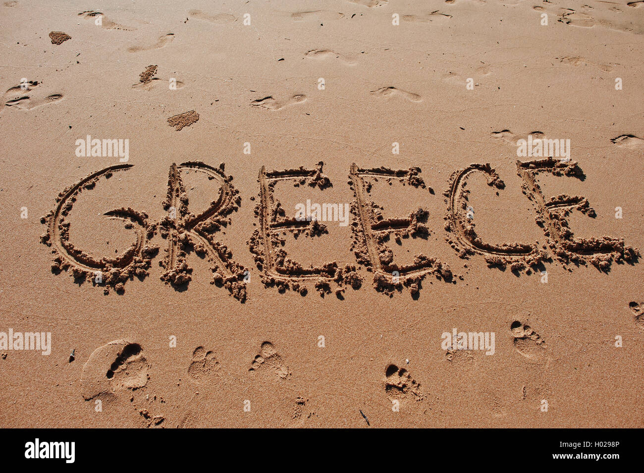 "Greece" written in the sand on the beach Stock Photo - Alamy