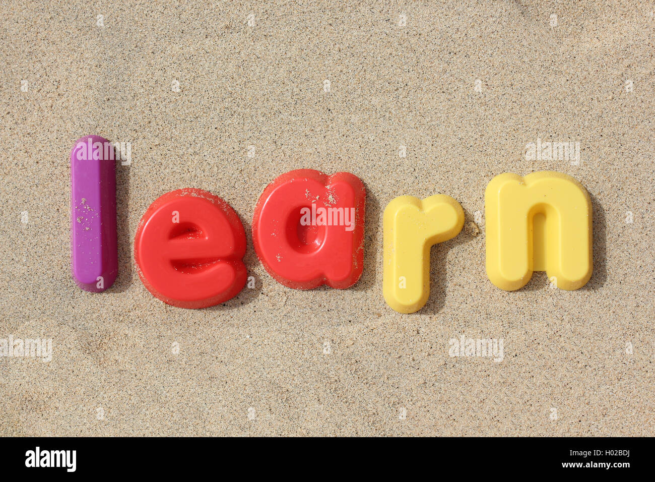 A playful image spelling out the word 'learn' with toy plastic letters ...
