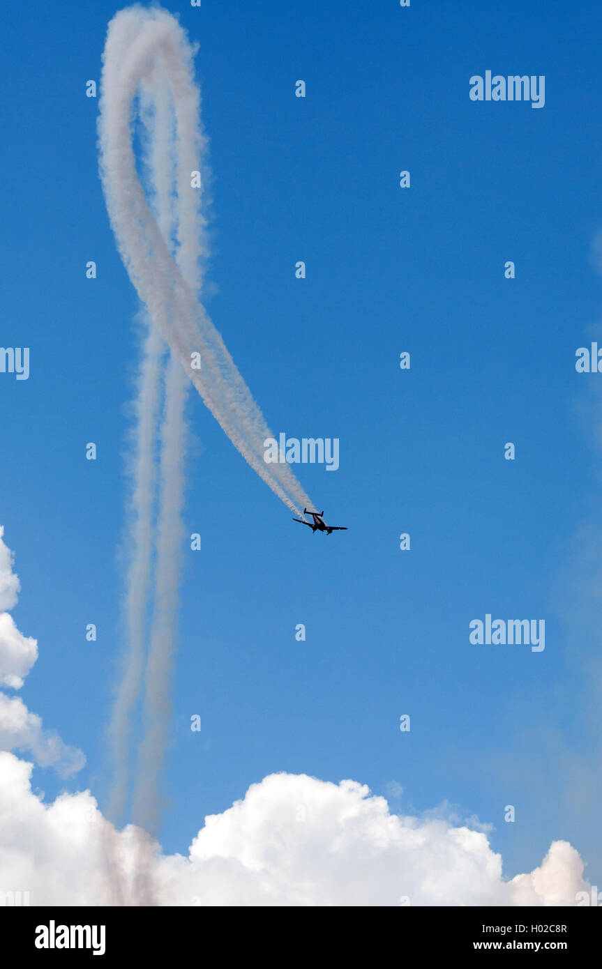 An airplane trailing smoke flies in a loop Stock Photo - Alamy