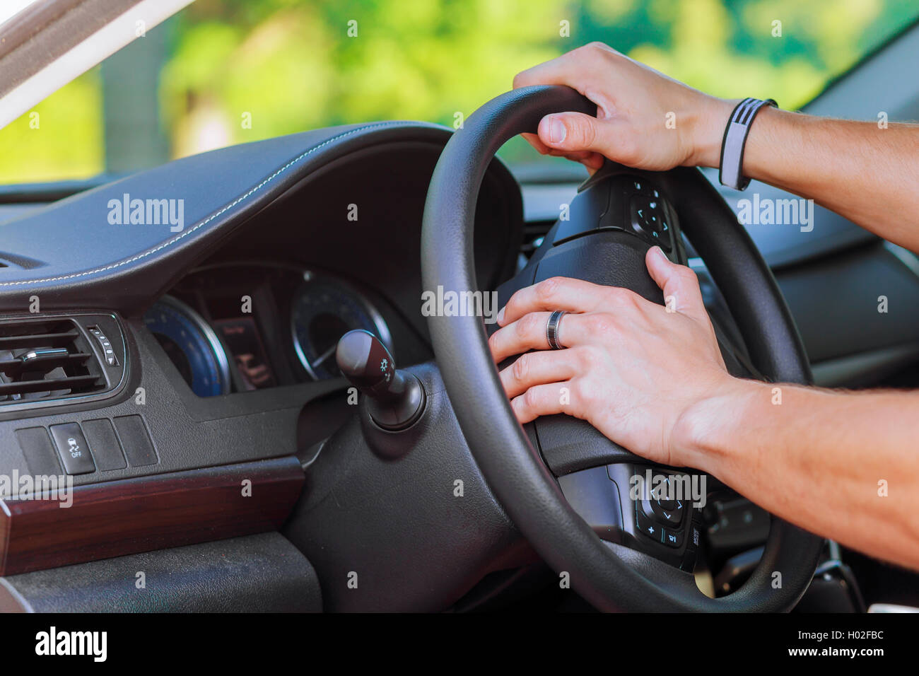Man's hand on the steering wheel of a car Stock Photo - Alamy