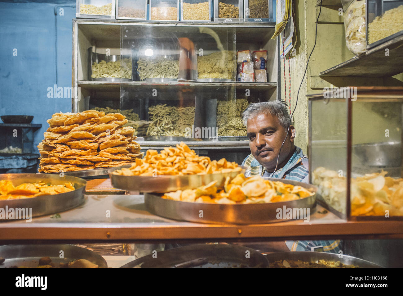 JODHPUR, INDIA - 16 FEBRUARY 2015: Vendor sits in store with various ...